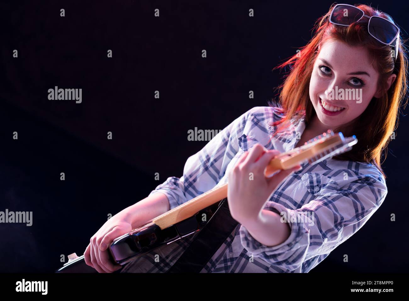 Red-headed musician in casual attire shares a charming smile, holding ...