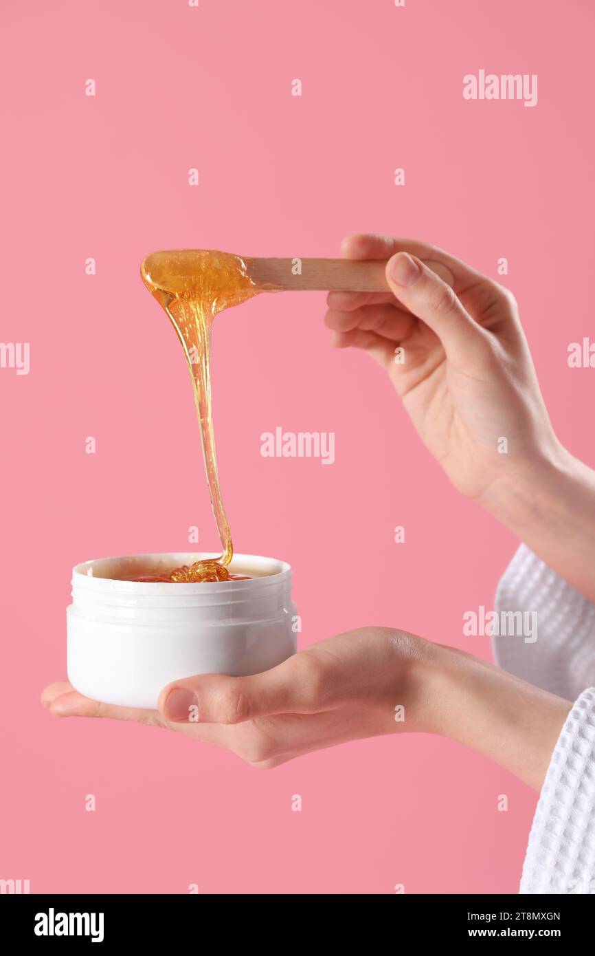 Hands with sugaring paste on pink background Stock Photo - Alamy