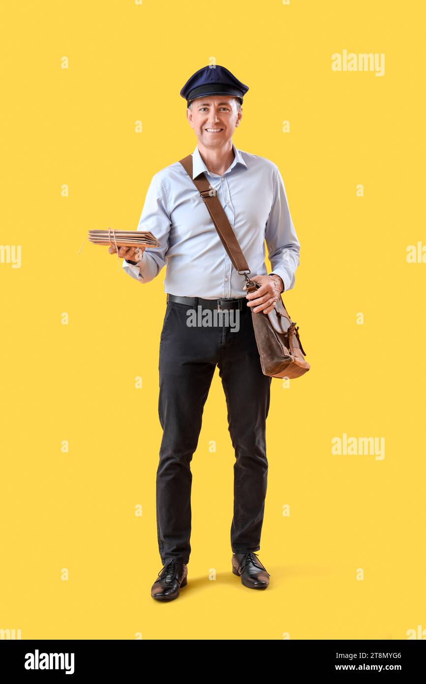 Mature postman with letters on yellow background Stock Photo - Alamy