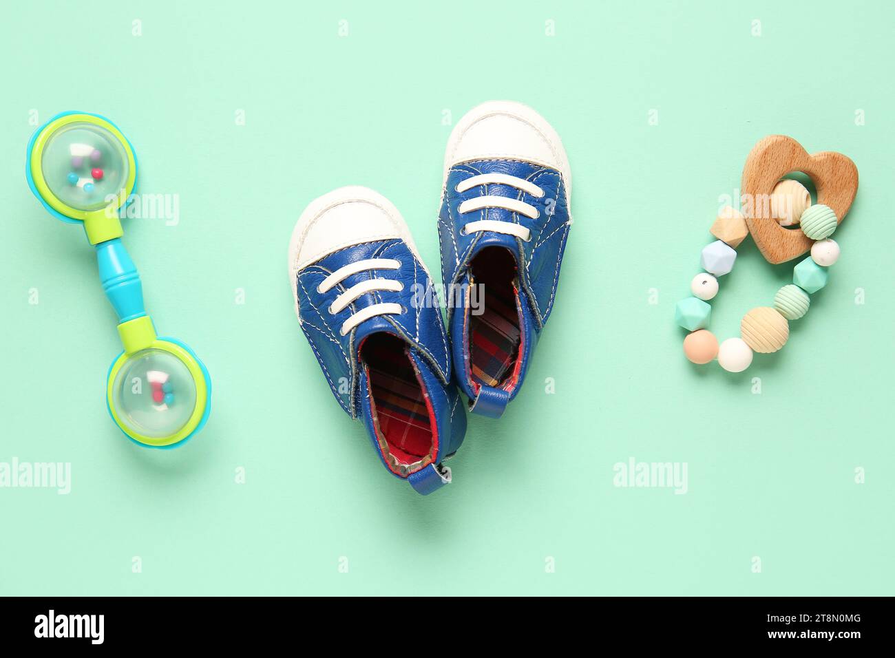 Stylish baby shoes with rattles on turquoise background Stock Photo - Alamy