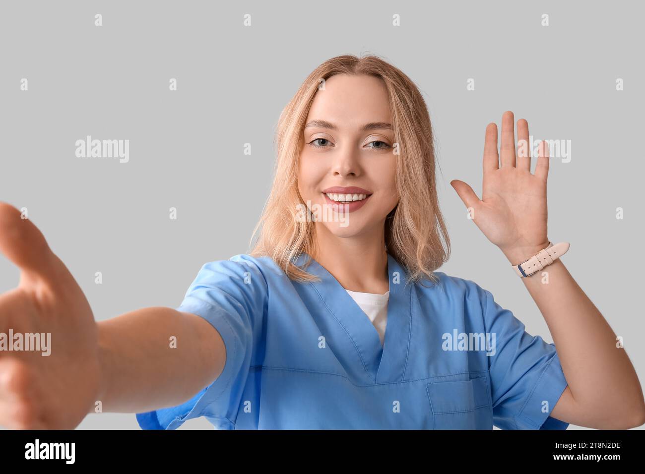 Beautiful female doctor waving hand and reaching out for handshake on ...