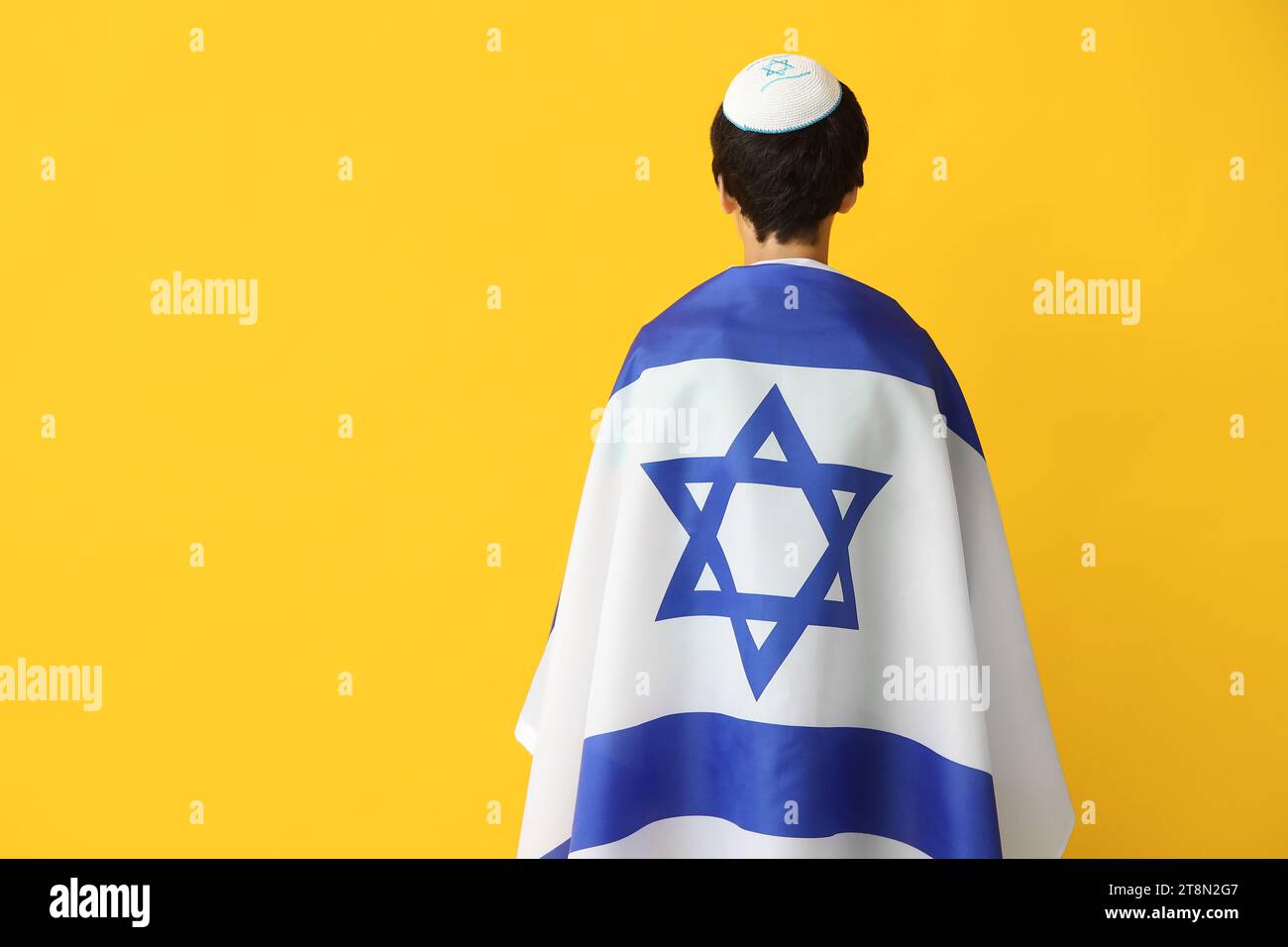 Little boy in kipa with Israel flag on yellow background, back view ...