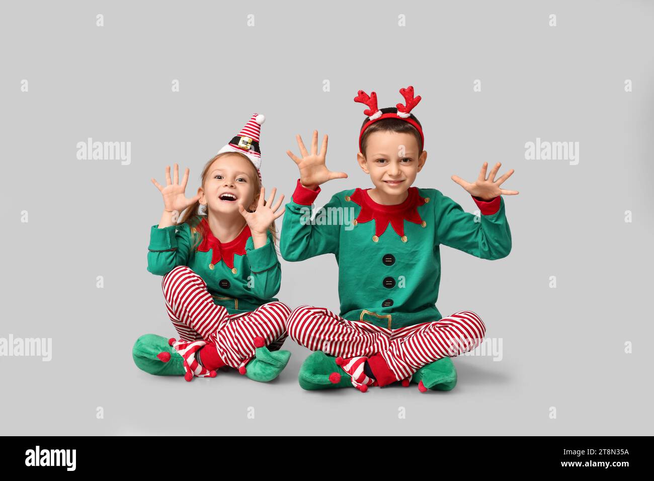Funny little children dressed as elves on grey background Stock Photo ...
