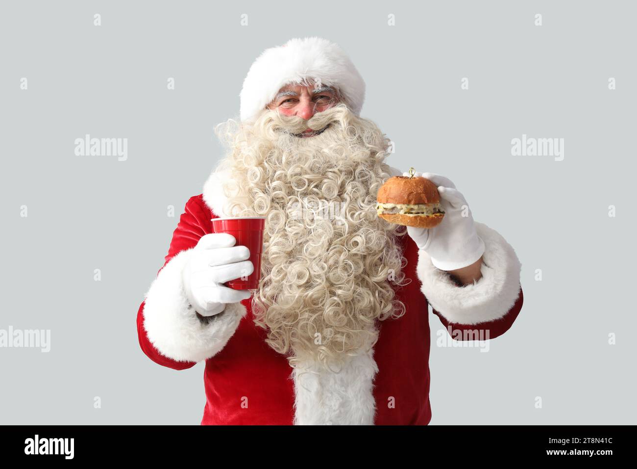 Santa Claus with cup of tea and tasty burger on white background Stock ...