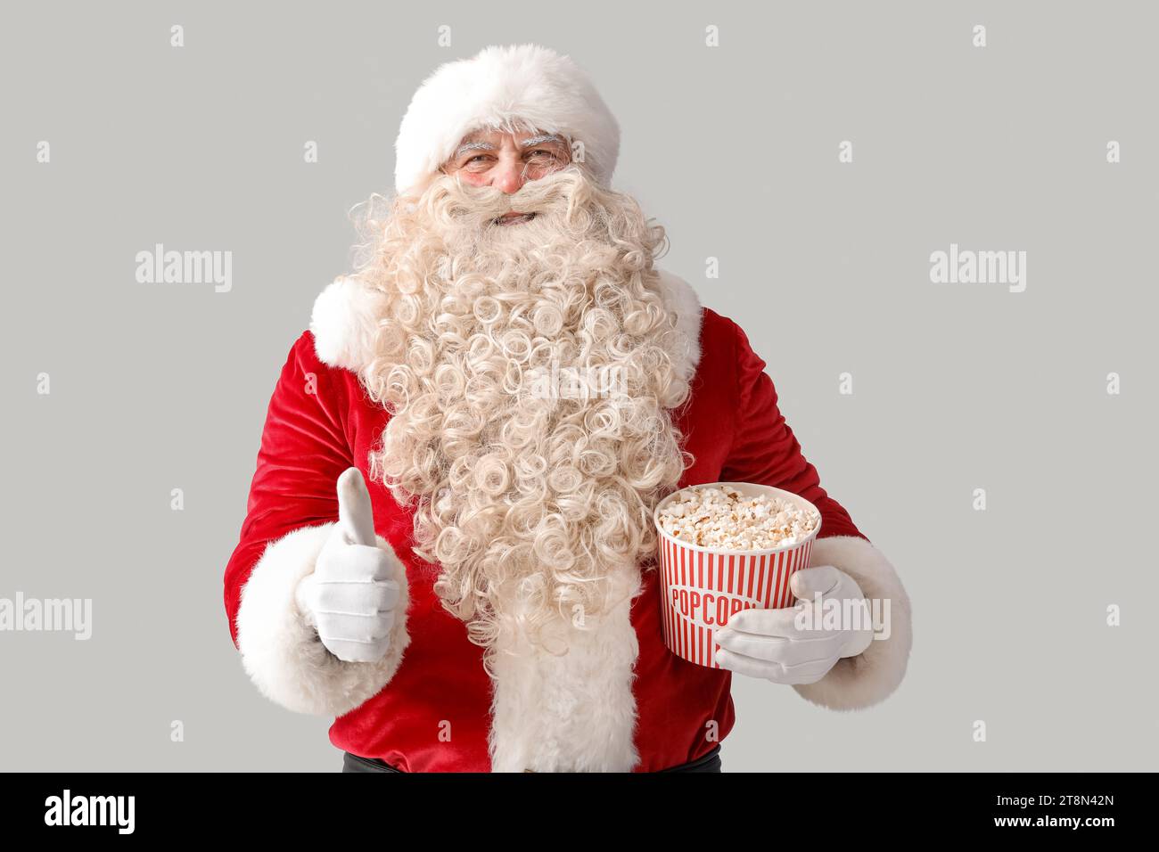 Santa Claus with tasty popcorn showing thumb-up on white background ...