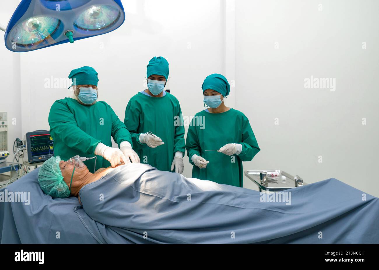 Group of surgeons, steeped in concentration, performing complex surgery ...