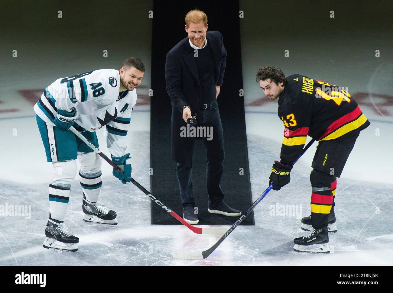 Prince Harry, center, Duke of Sussex, drops the puck for San Jose ...