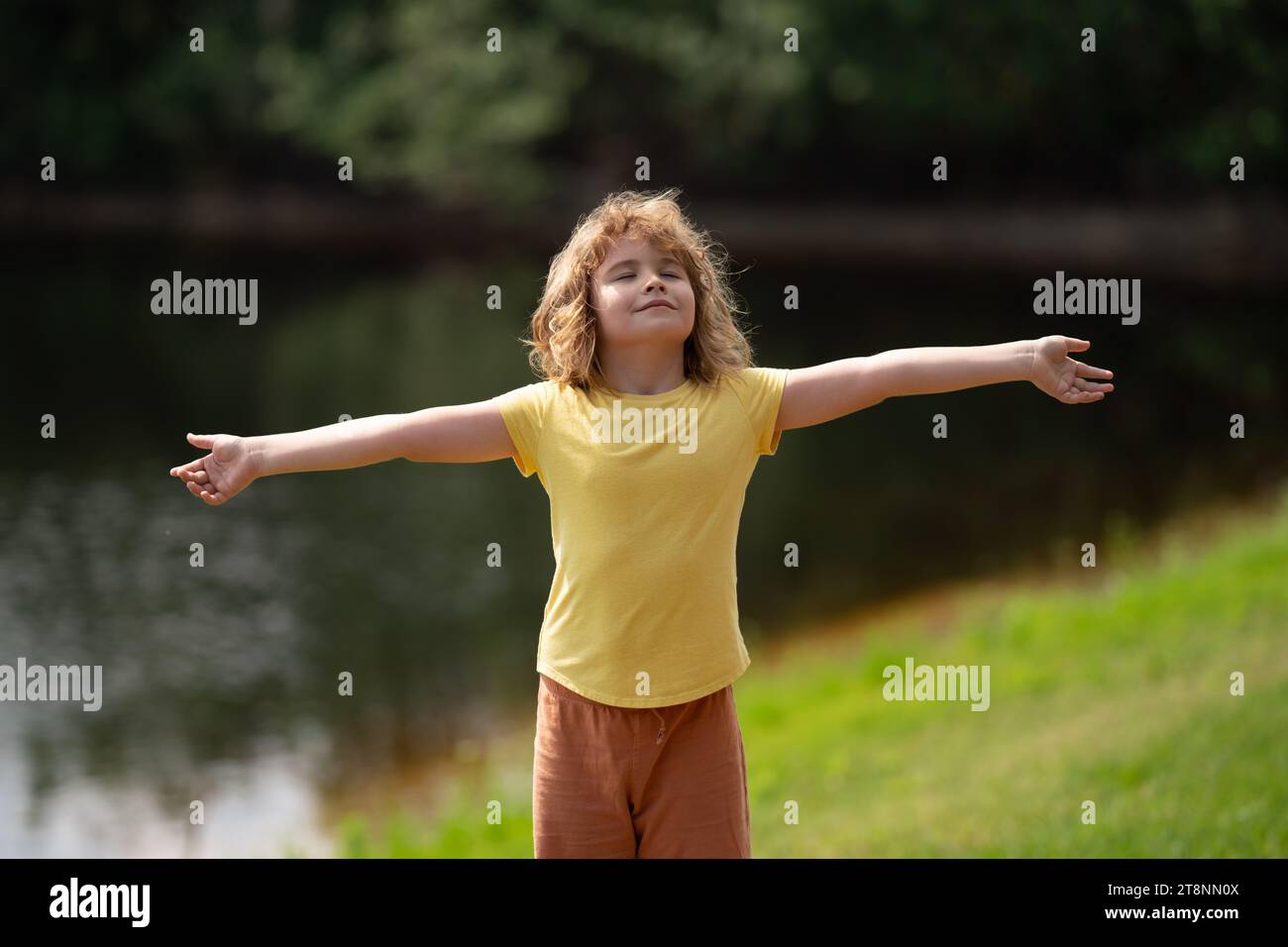 Happy kid with arms up enjoying freedom in nature. Kid enjoying freedom ...