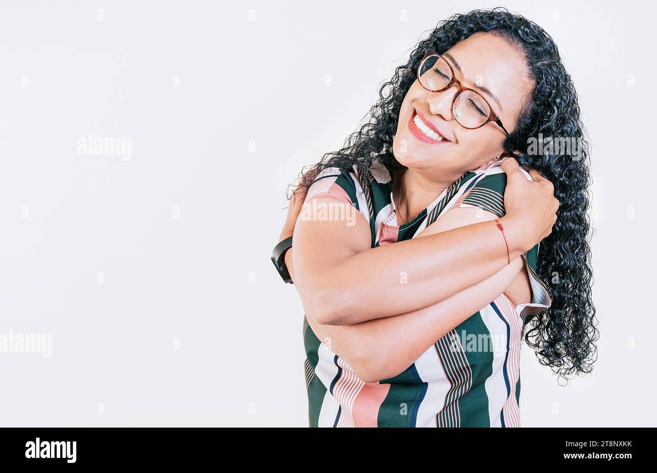 Smiling young woman hugging herself with self love. Self love concept ... Smiling young woman hugging herself with self love. Self love concept ...