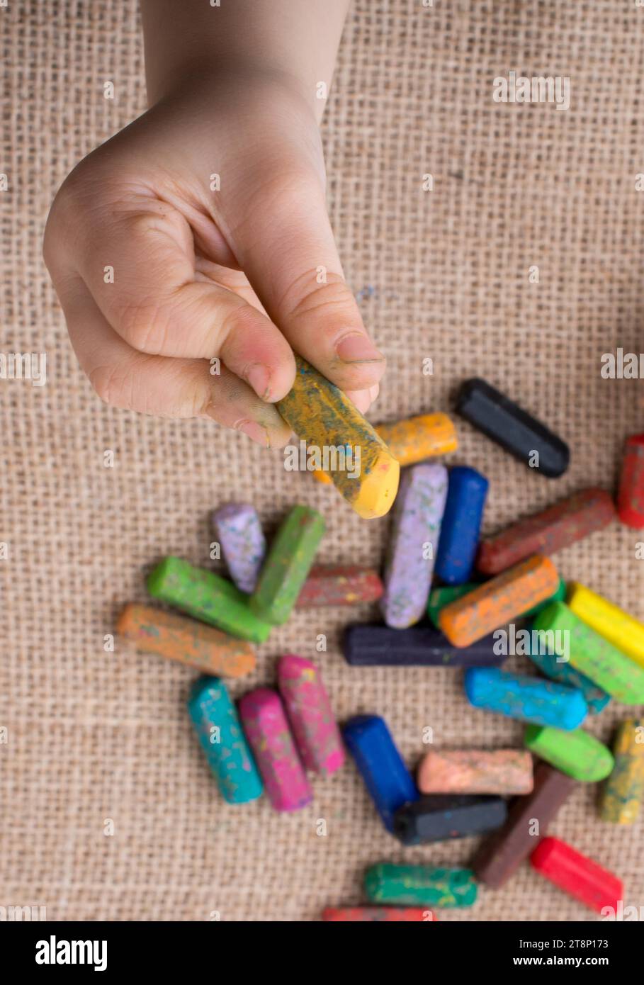 Used color crayons and a toddlers hand holding one Stock Photo - Alamy