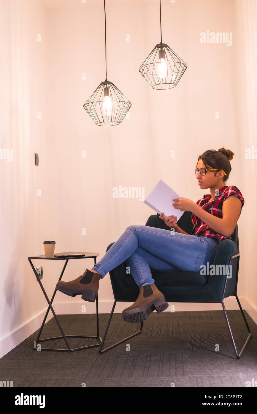 Vertical photo of a woman reading a book in a cozy space at home Stock ...