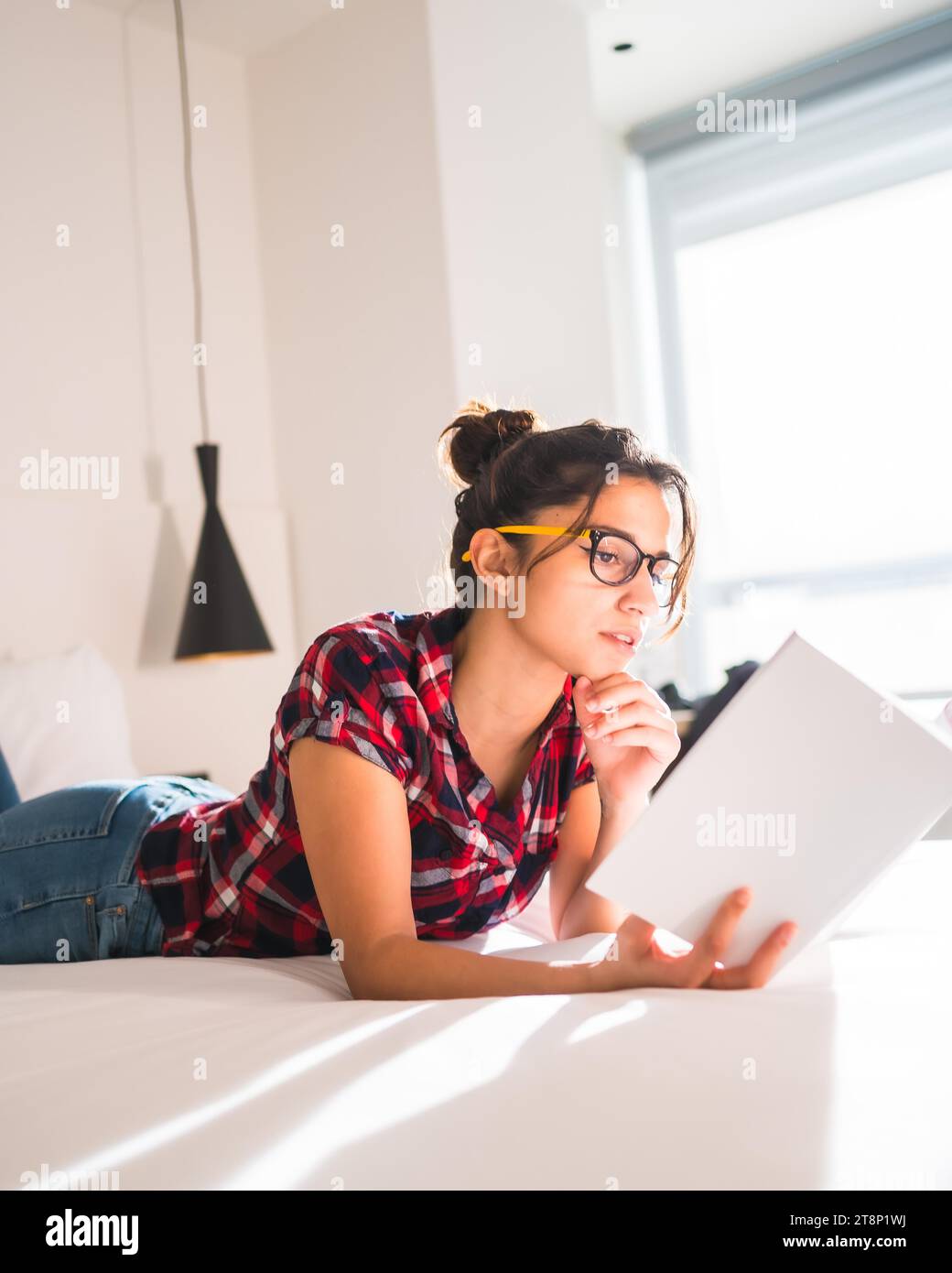 Side view of a beauty young woman reading an interest novel in an hotel ...