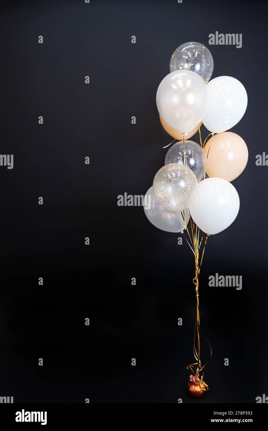 On a black background, balloons of light shades - white, beige ...