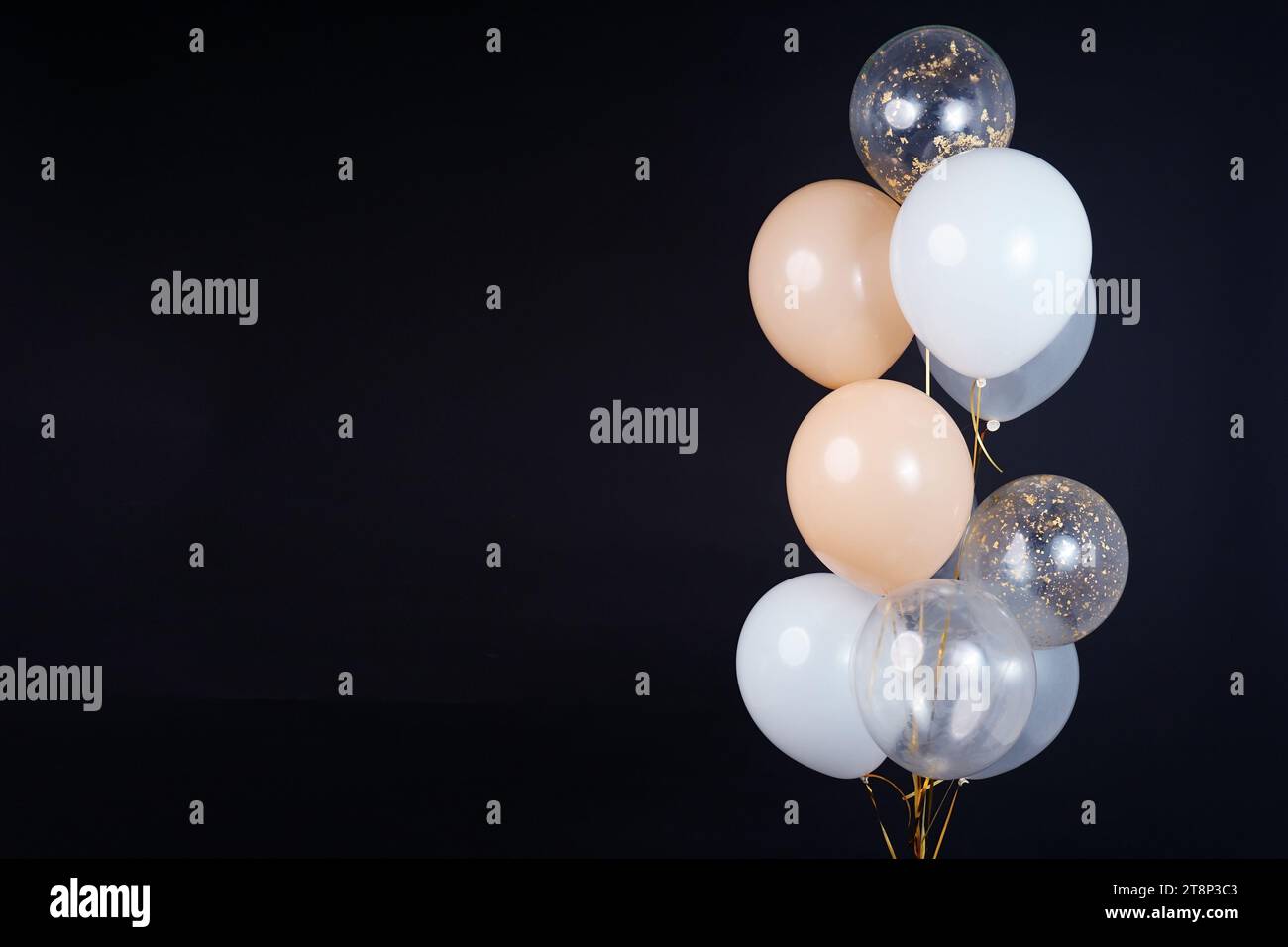 A bunch of balloons in white, beige and transparent colors on a dark ...