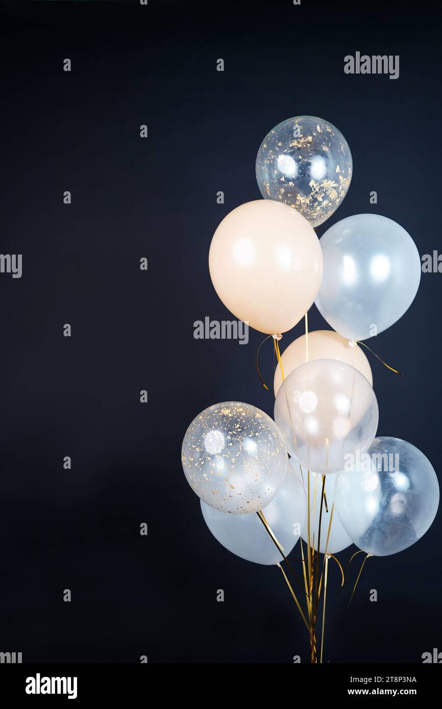 On a black background, balloons of light shades - white, beige ...