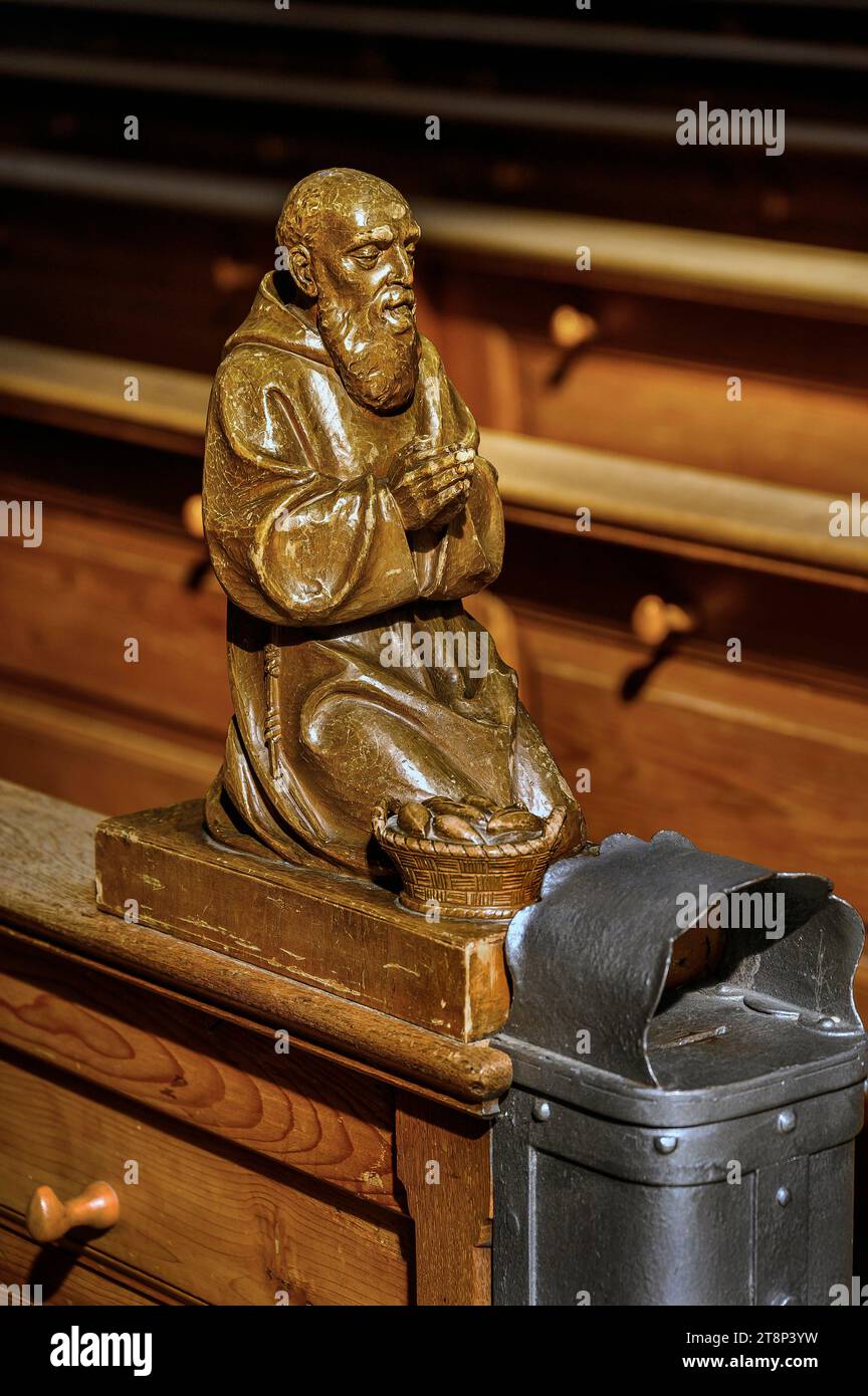 Praying figure on a church bench, in St.Stephan, Minelheim, Bavaria ...
