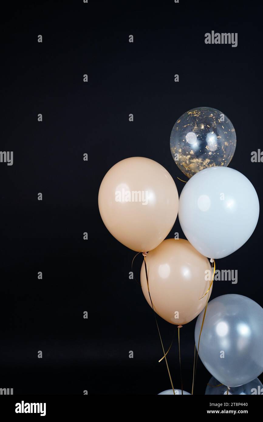 On a black background, balloons of light shades - white, beige ...