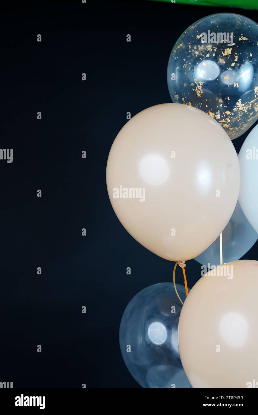 On a black background, balloons of light shades - white, beige ...