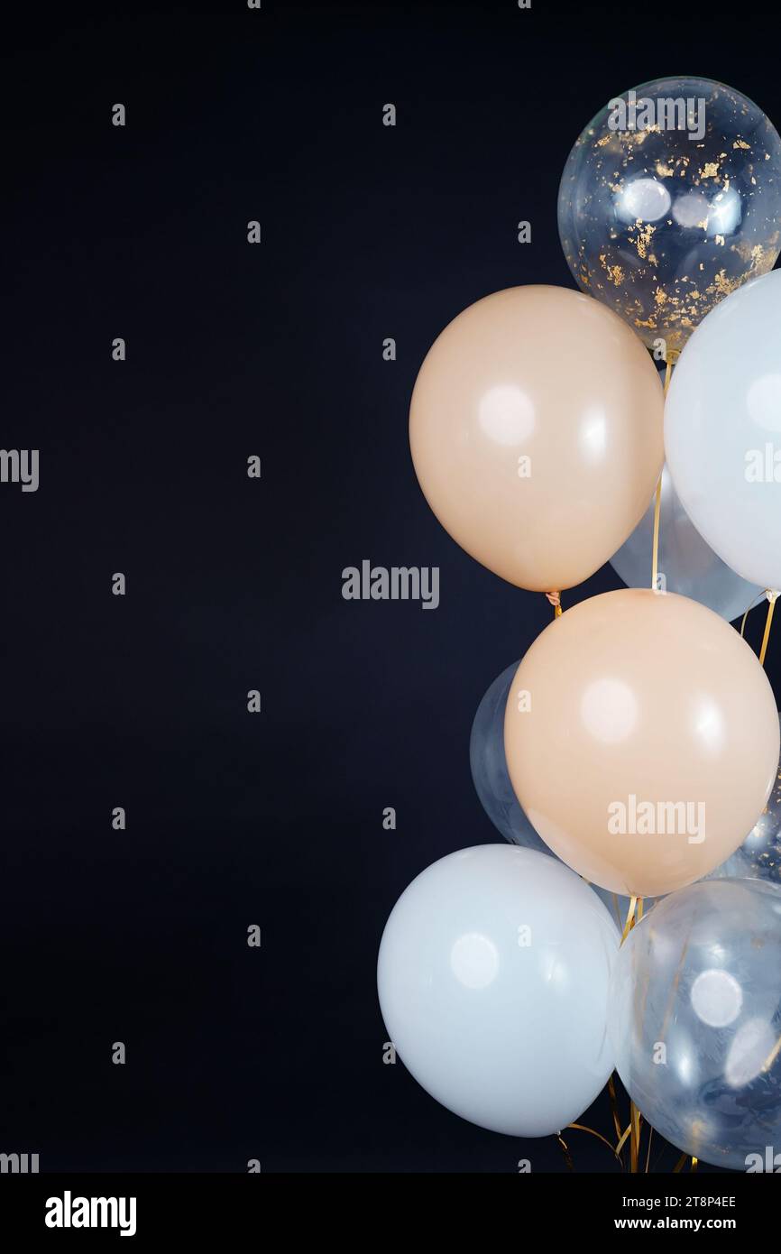 On a black background, balloons of light shades - white, beige ...