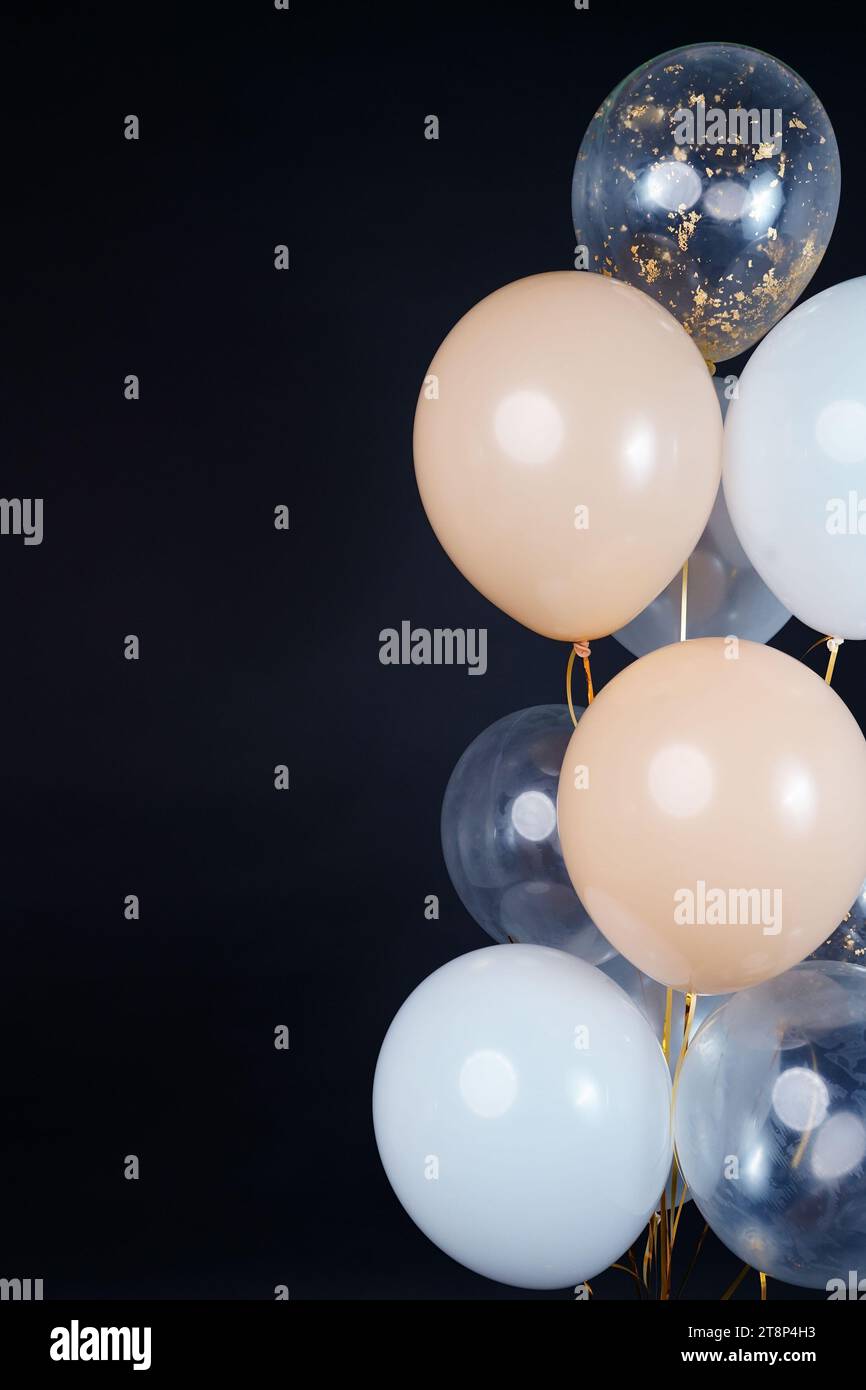 On a black background, balloons of light shades - white, beige ...