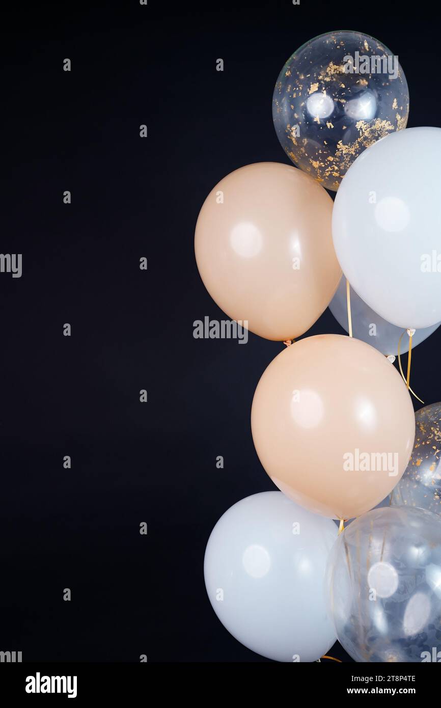 On a black background, balloons of light shades - white, beige ...