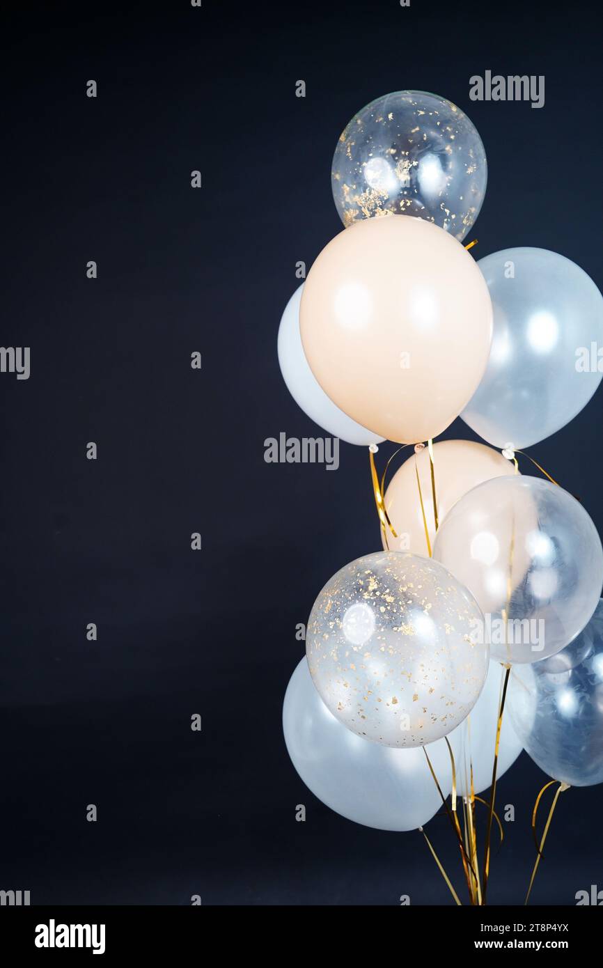 On a black background, balloons of light shades - white, beige ...