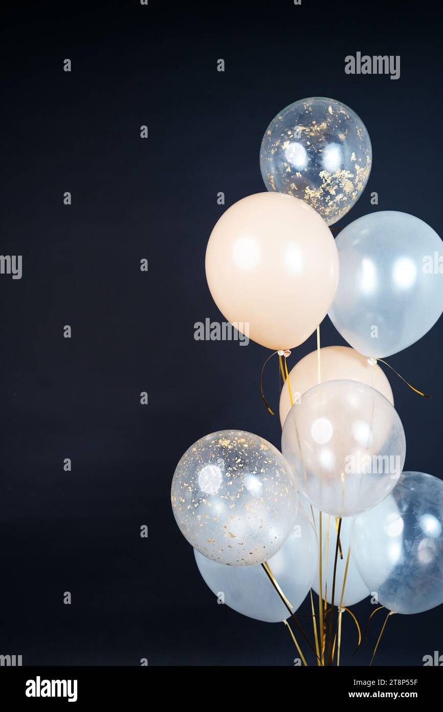 On a black background, balloons of light shades - white, beige ...