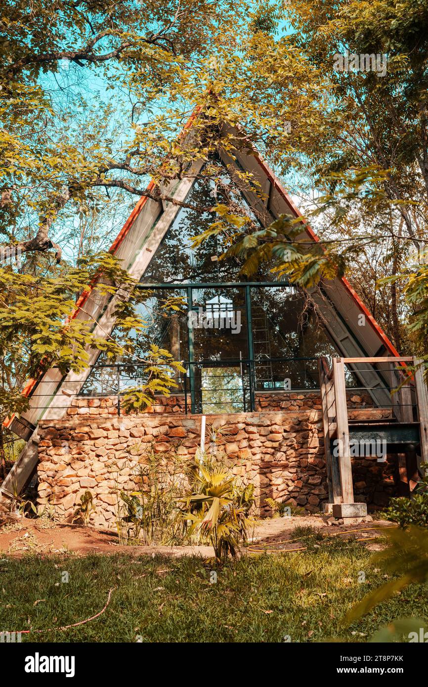 This photo depicts a triangle-shaped house situated in a wooded area ...