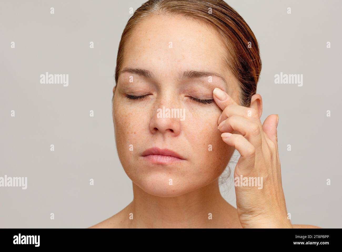 Middle aged caucasian woman of 40s with closed eyes holding finger on ...
