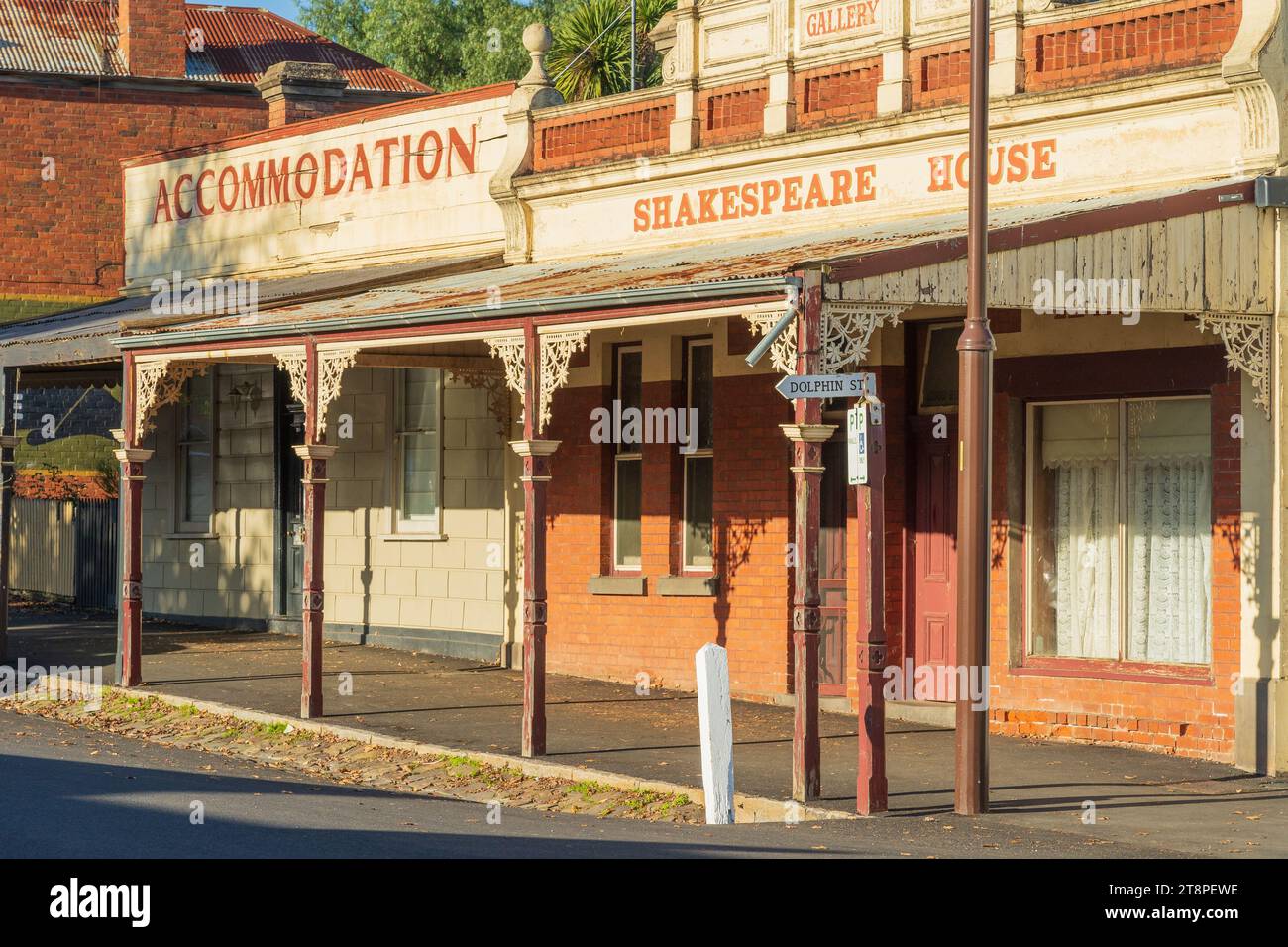 Wrought iron and ornate veranda posts in front of old buildings facades ...