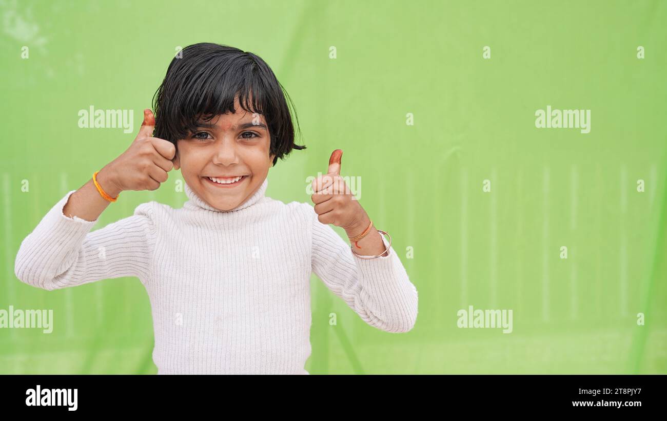 Portrait of attractive funny cheerful little girl showing double thumb ...