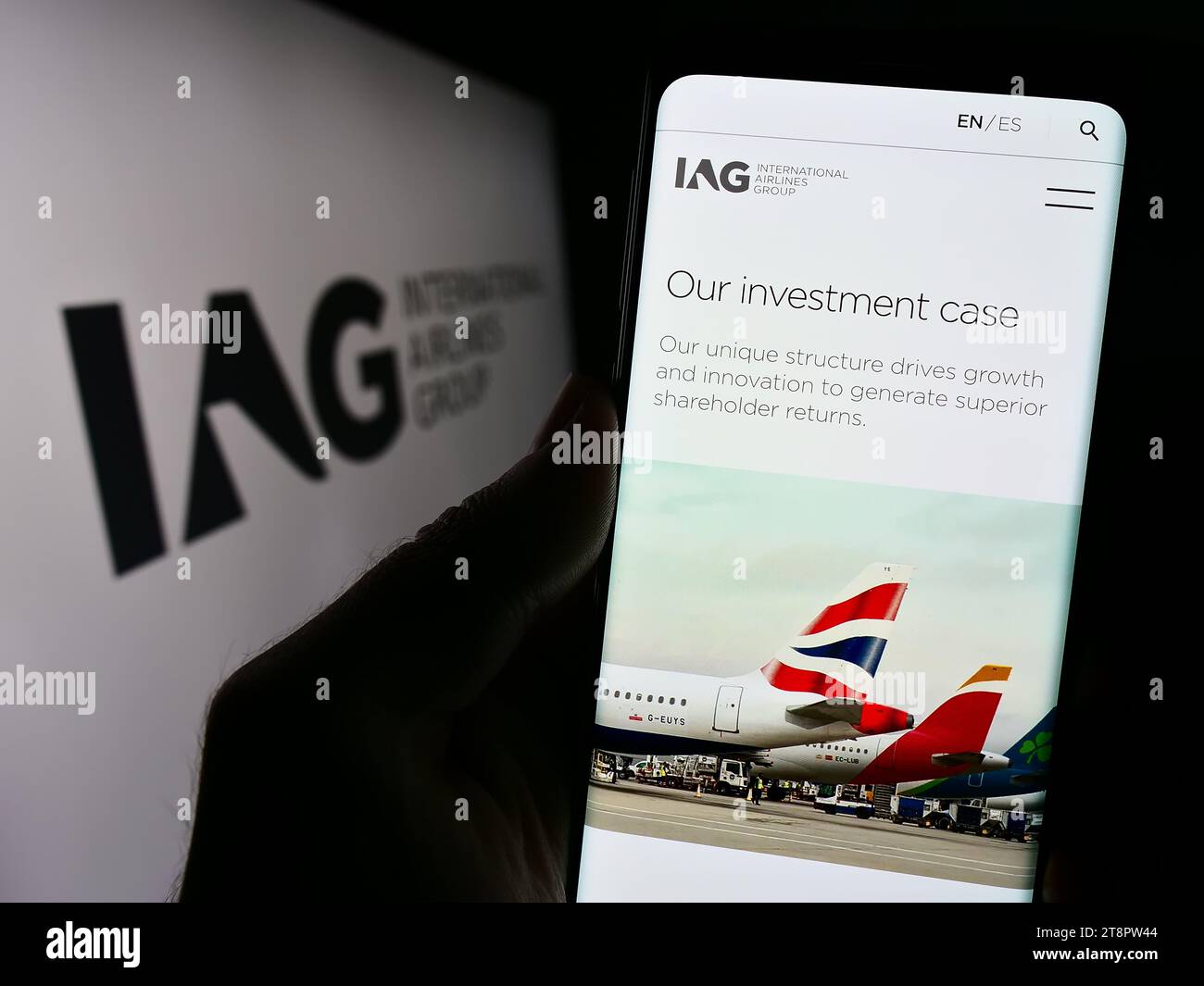 Person holding cellphone with webpage of International Consolidated ...