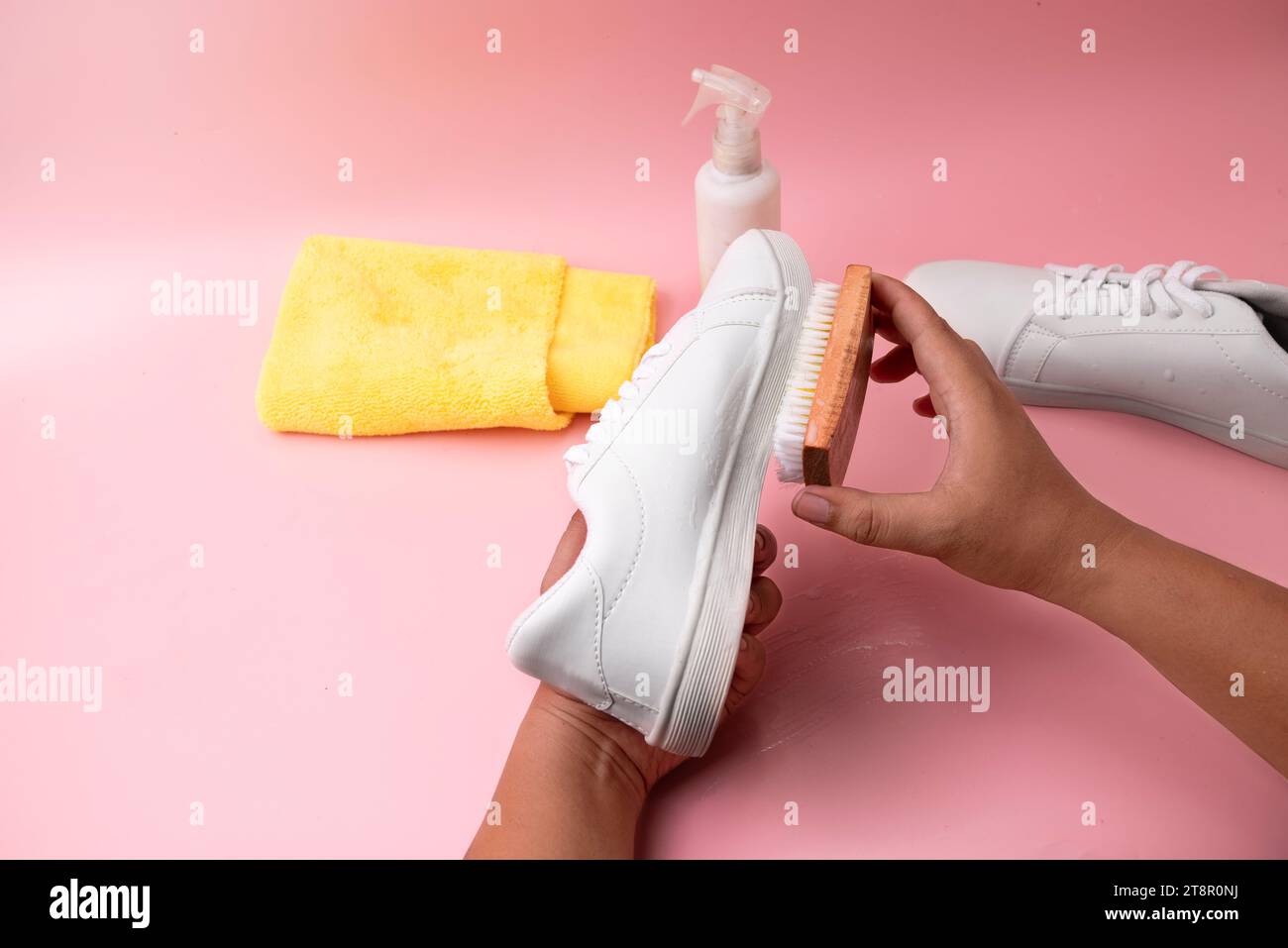 Human hand cleaning white sneakers with a brush. Shoe care concept ...
