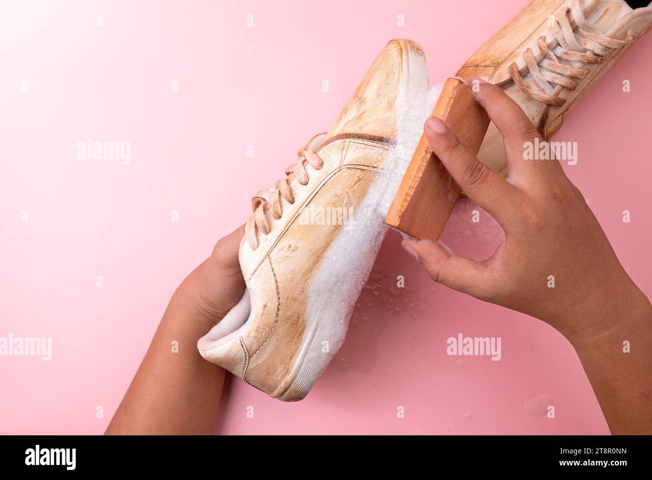 Human hand cleaning white sneakers with a brush. Shoe care concept ...