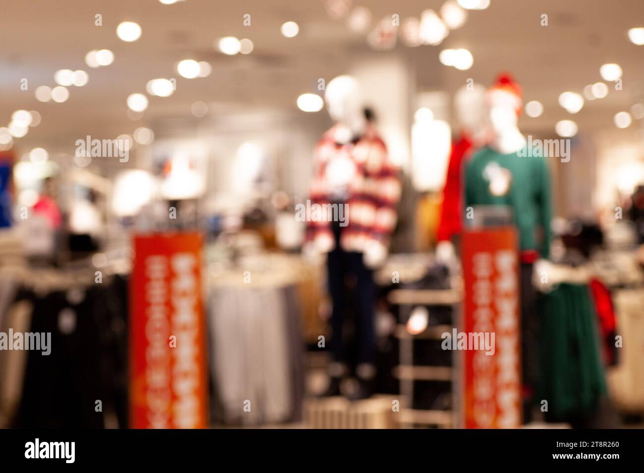 Blurry view of a bustling mall interior with various shops and ...