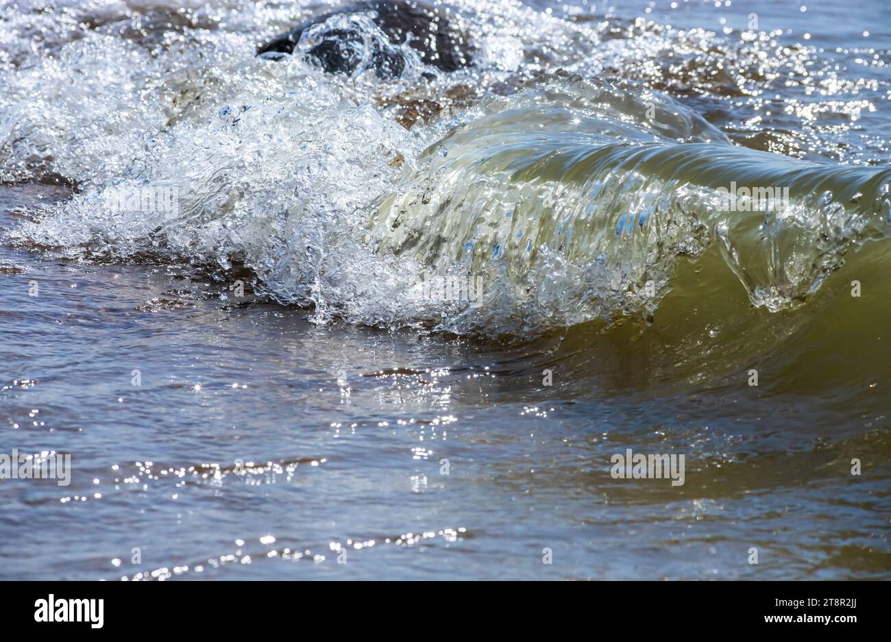 Sea wave with spray and foam near the shore Stock Photo - Alamy