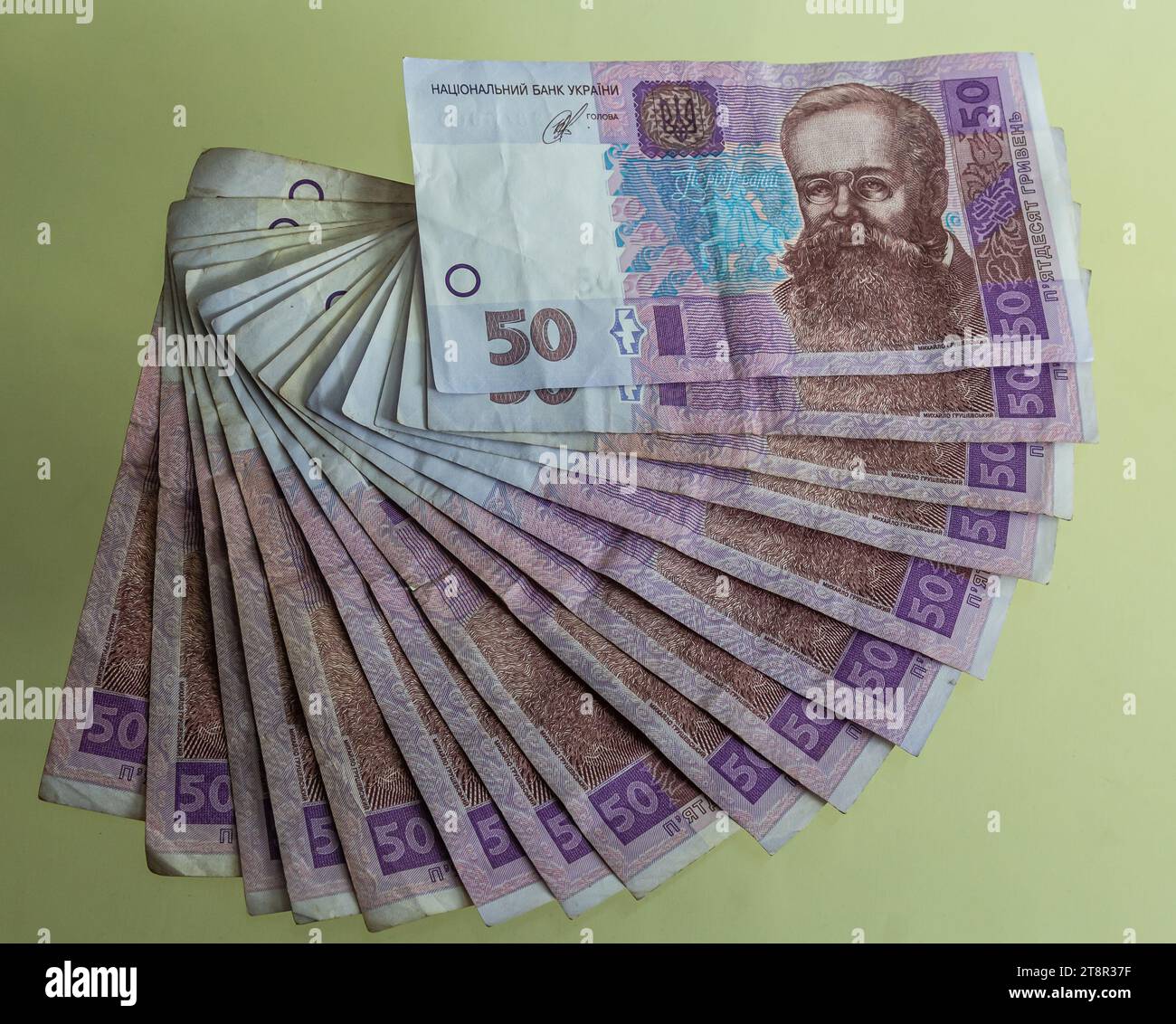 Ukrainian paper money is laid out on a blue background. 50 hryvnia ...