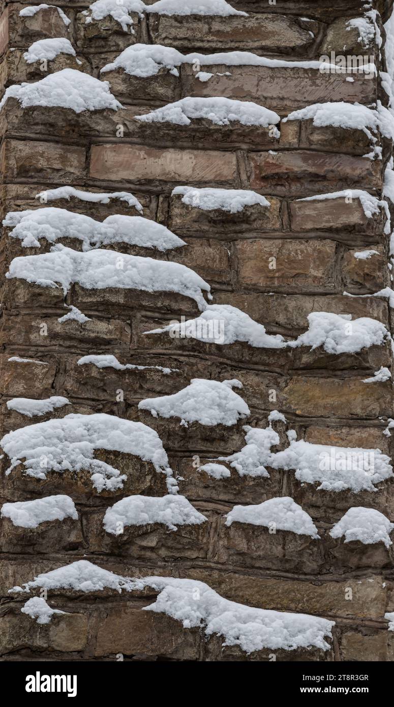 Medieval stone wall is covered with snow, design background with place ...