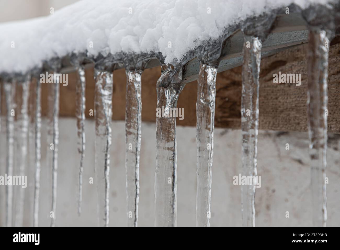 Icicles on the roof. The drain is full of snow and ice. Icicles falling ...