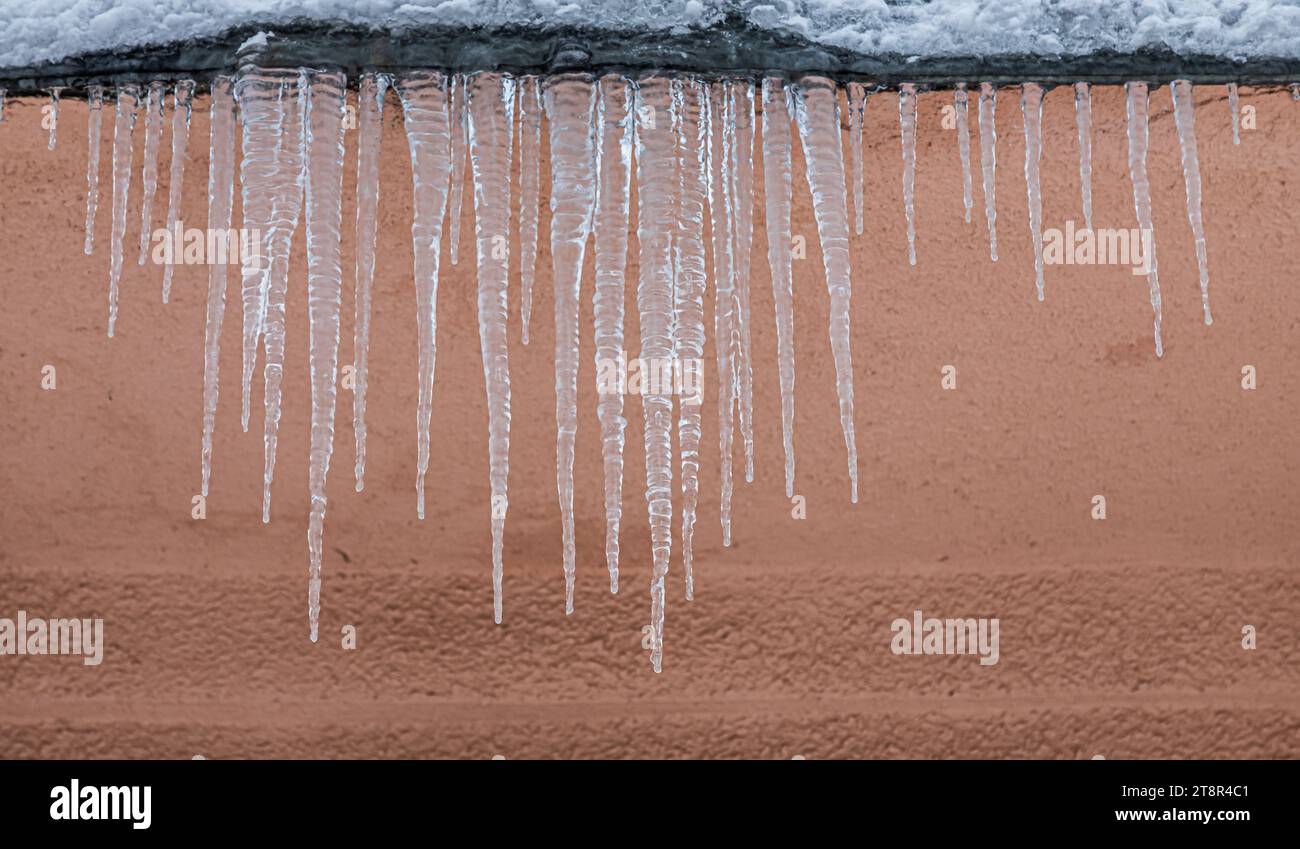 Icicles on the roof. The drain is full of snow and ice. Icicles falling ...