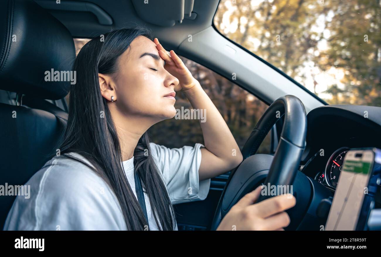 Tired young woman car driver suffering from headache migraine driving ...