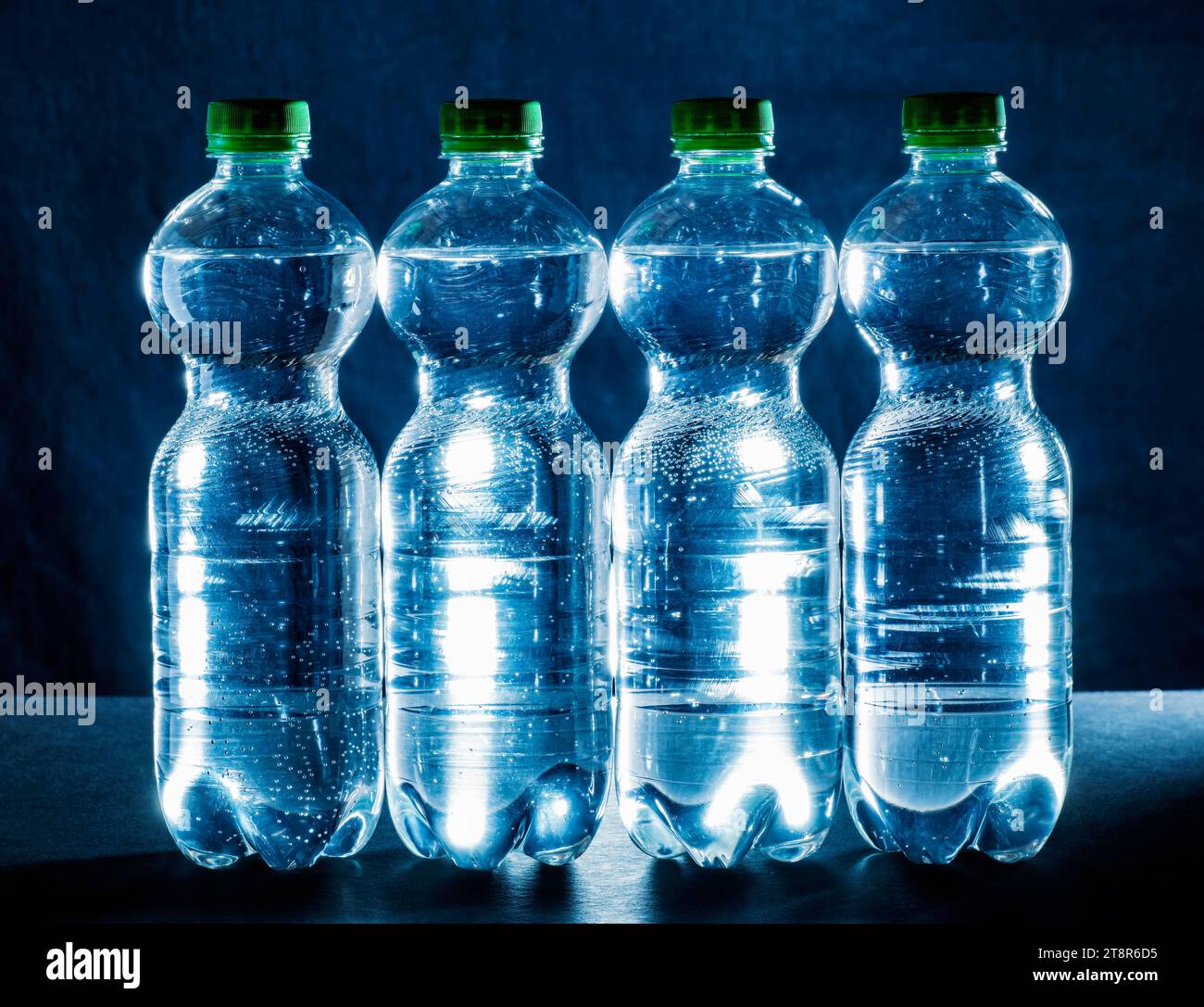 Four plastic bottles with water in front of a dark background Stock ...