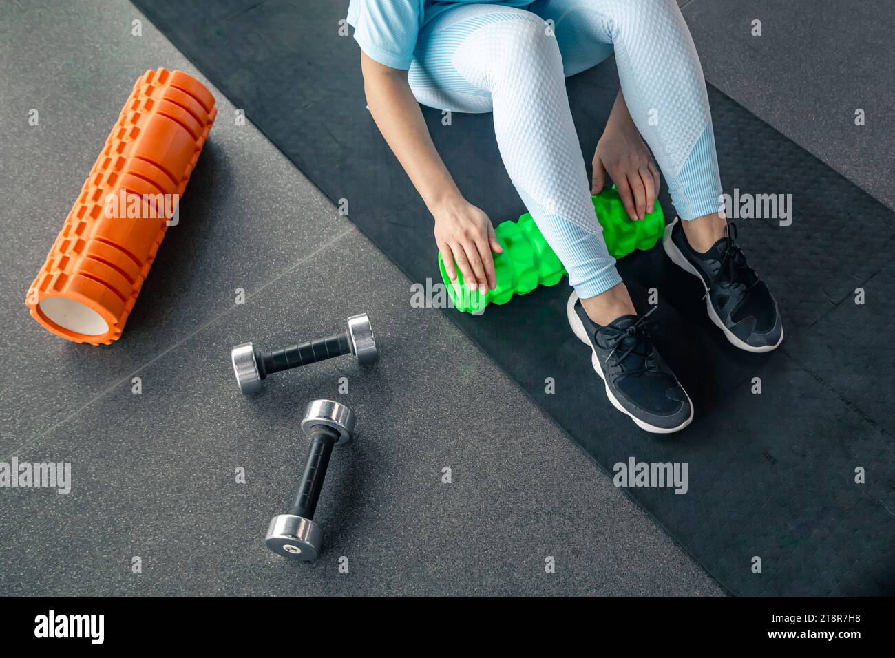 Sport woman using foam roller for muscle and fascia stretching foot ...