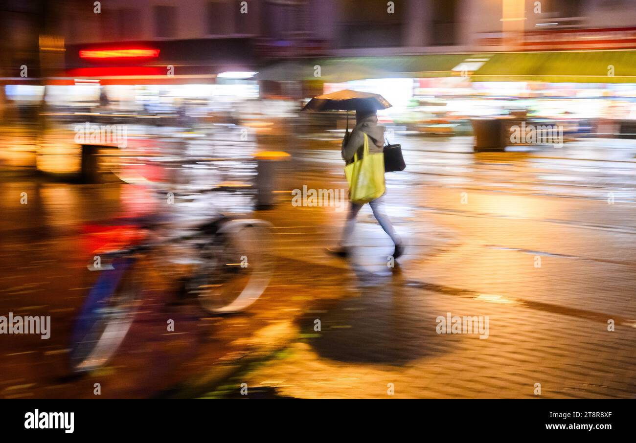 Hanover, Germany. 21st Nov, 2023. A woman with an umbrella walks along ...