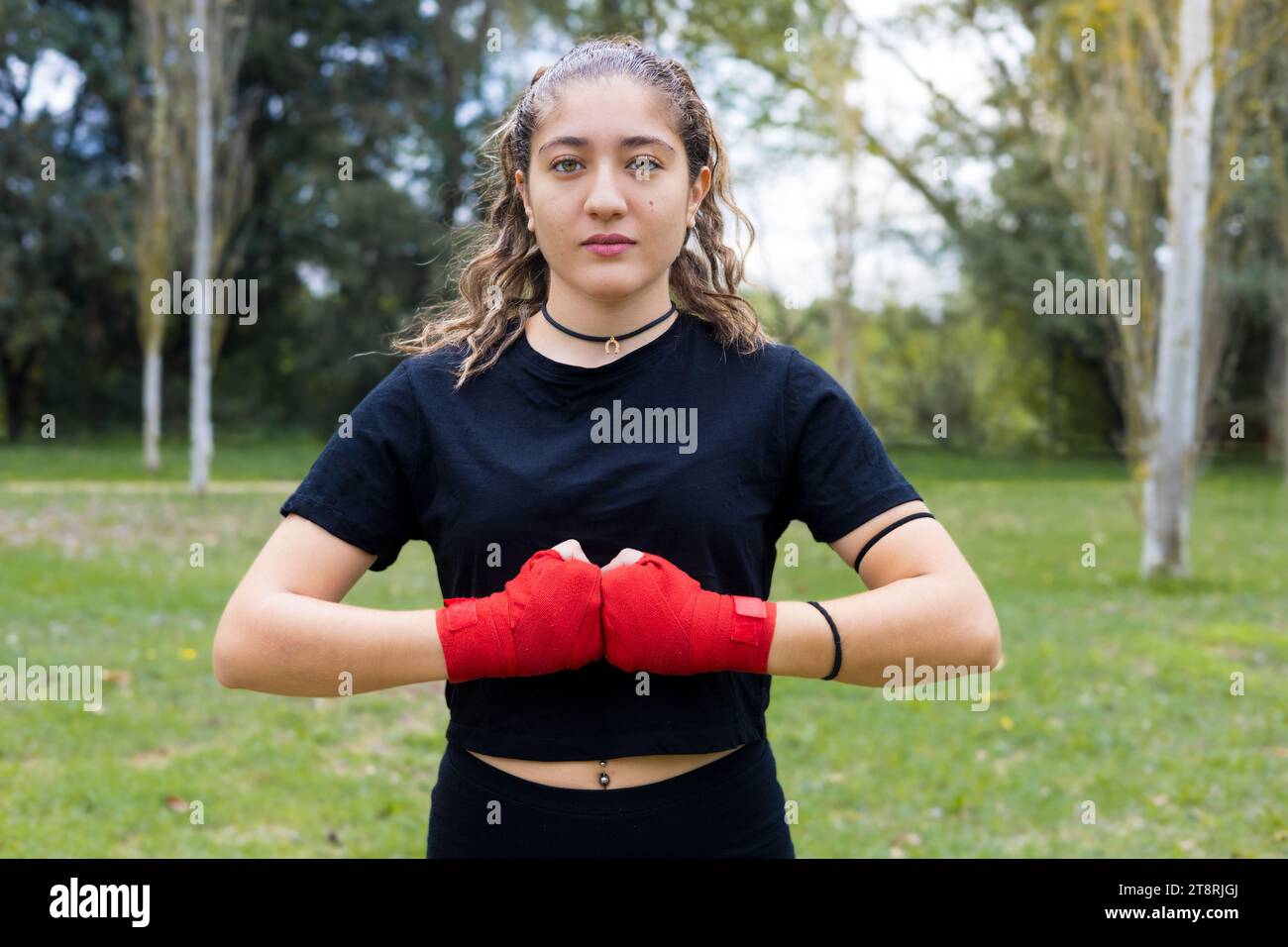 Female boxer portrait with hands red bandage wrap for boxing workout ...