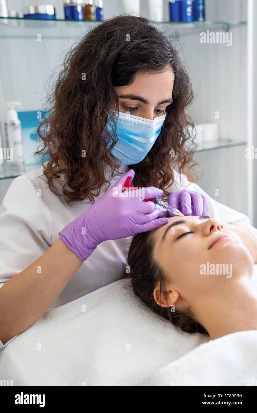 Cosmetologist making rejuvenating anti wrinkle injections on the face ...