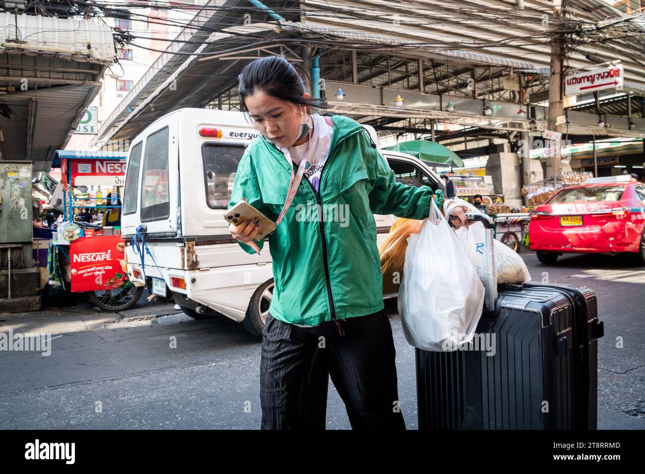A tourist makes her way around Pratunam Market, Bangkok Thailand. Using ...
