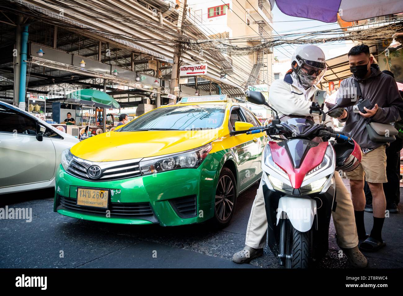 A taxi makes its way through the busy streets of Pratunam market ...