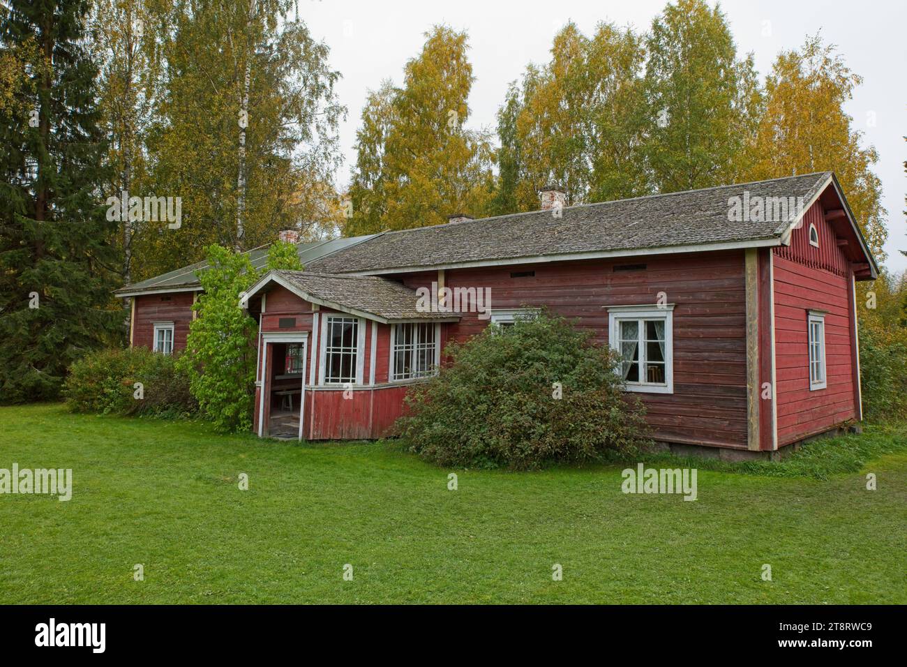 Old weathered traditional painted red wooden building in cloudy autumn ...