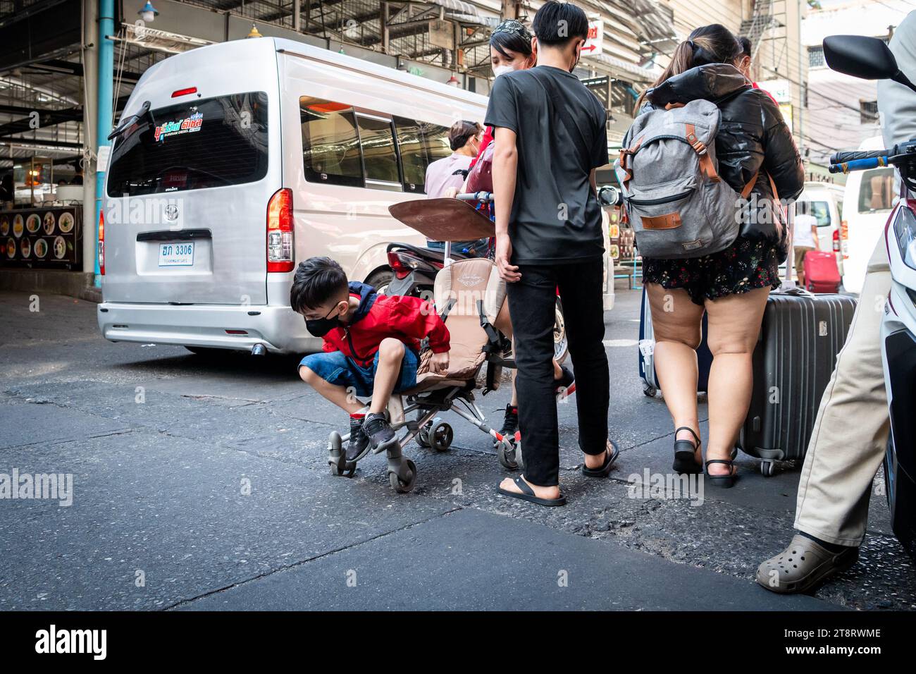 A young boy takes a tumble falling from his pram in the busy streets of ...
